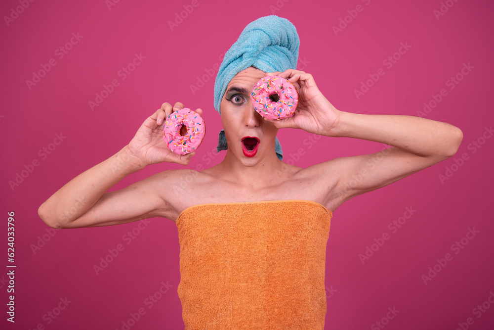 Funny drag queen poses in the studio on a pink background and eats ...