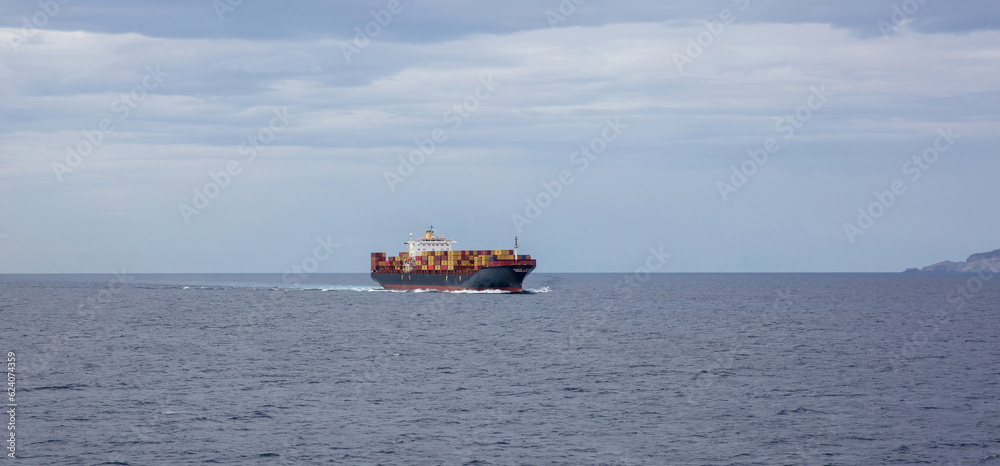 Container cargo ship full loaded is sailing in open sea background ...