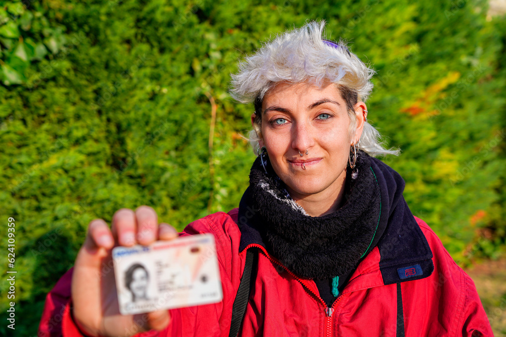 smiling non-binary and pride person showing their new ID to camera ...