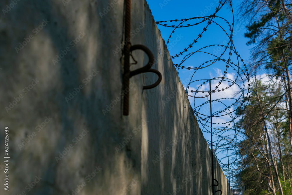 barbed wire on a concrete fence. concept prison, border, penetration ...