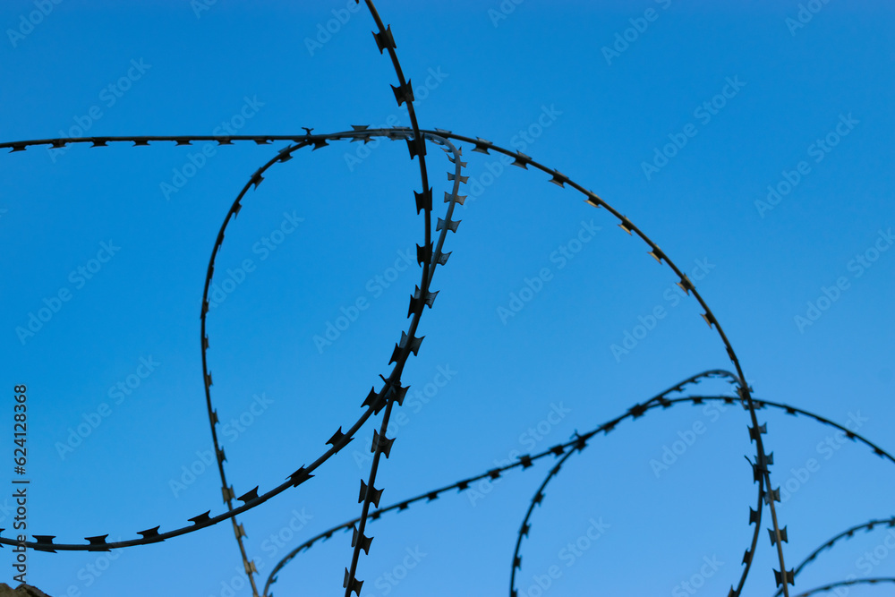 barbed wire on a concrete fence. concept prison, border, penetration ...