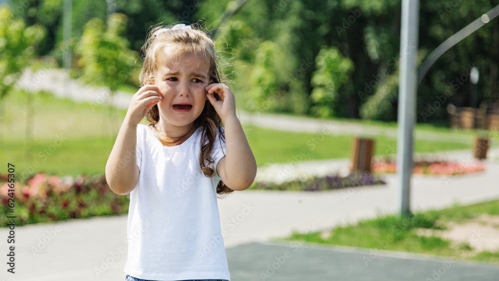 Cute caucasian baby, little girl crying on the playground in the park ...
