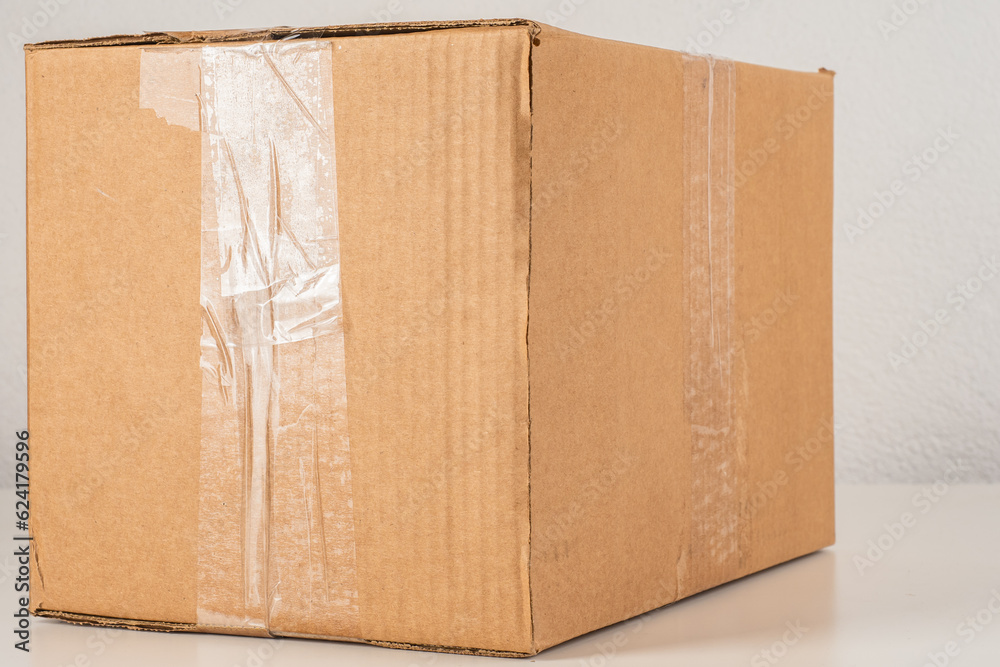 Foto de Cardboard box. Package wrapped with tape. Cardboard box for ...