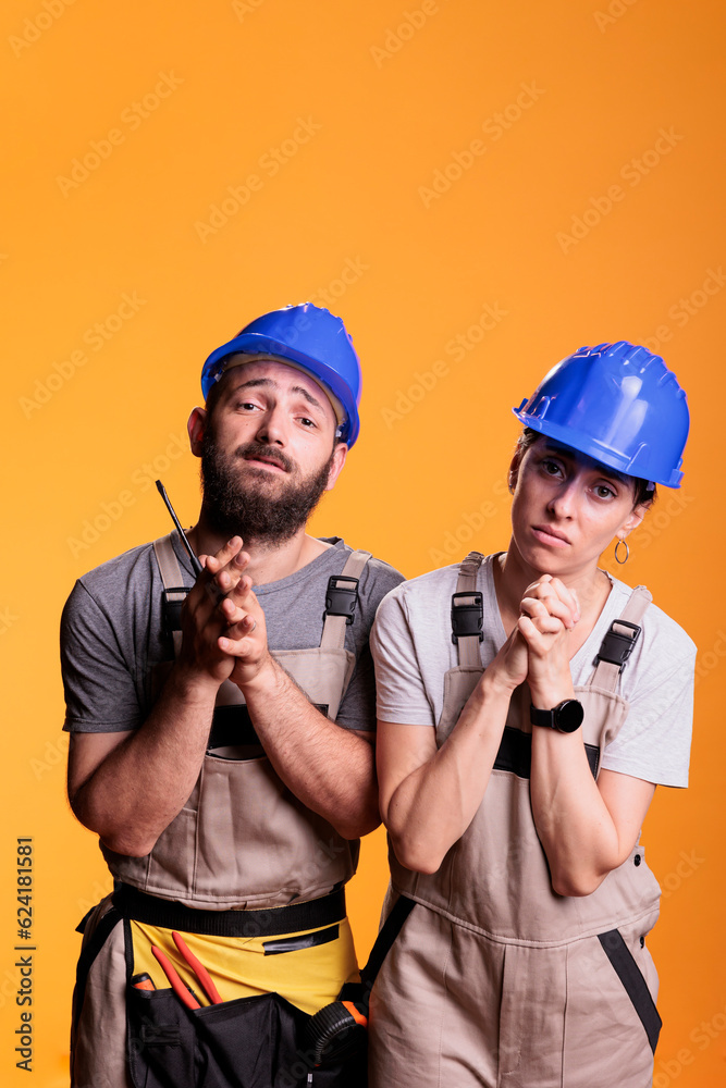 Religious repairman and woman praying to god for good projects, begging ...