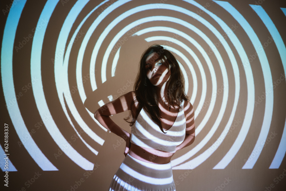 young adult woman or teenager girl in trendy outfit in dark room with ...