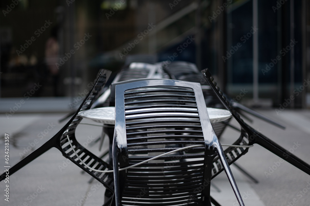 Chairs are tied up and placed facing a table, an example of defensive ...