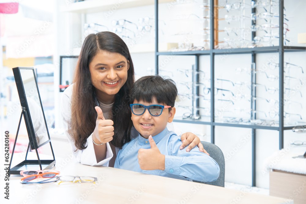 Indian cute child boy trying and wearing new eyeglasses frame with ...