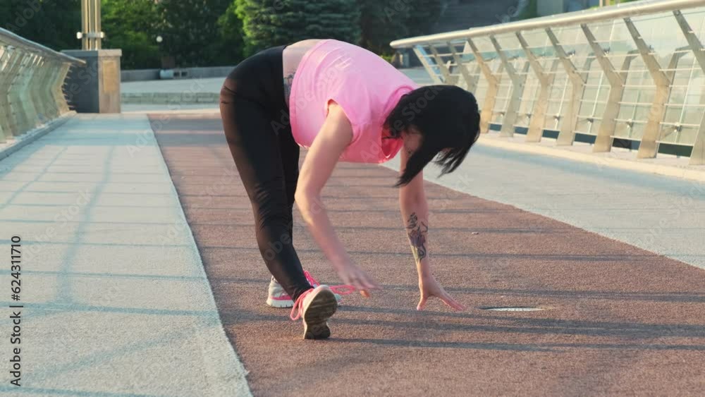 Woman with legs wide apart makes deep body bends forward in morning ...