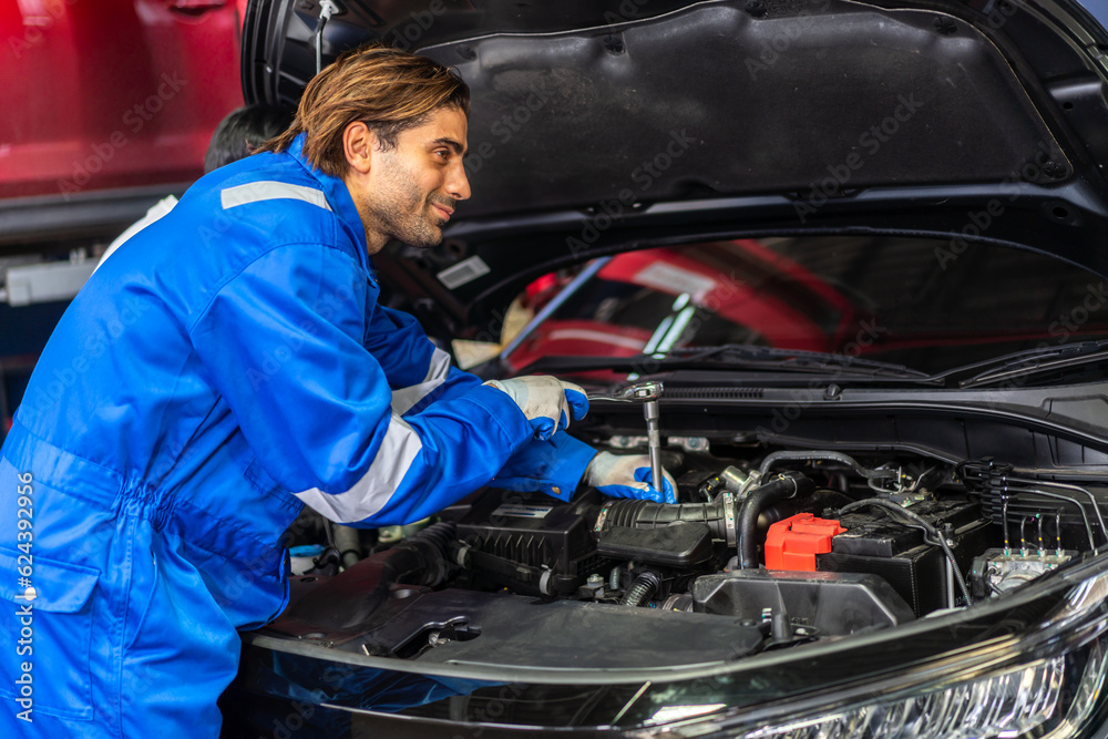 Professional car technician mechanic man in uniform work fixing vehicle ...