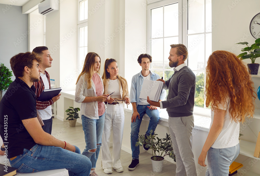 Group of students having class with their creative teacher. Male ...