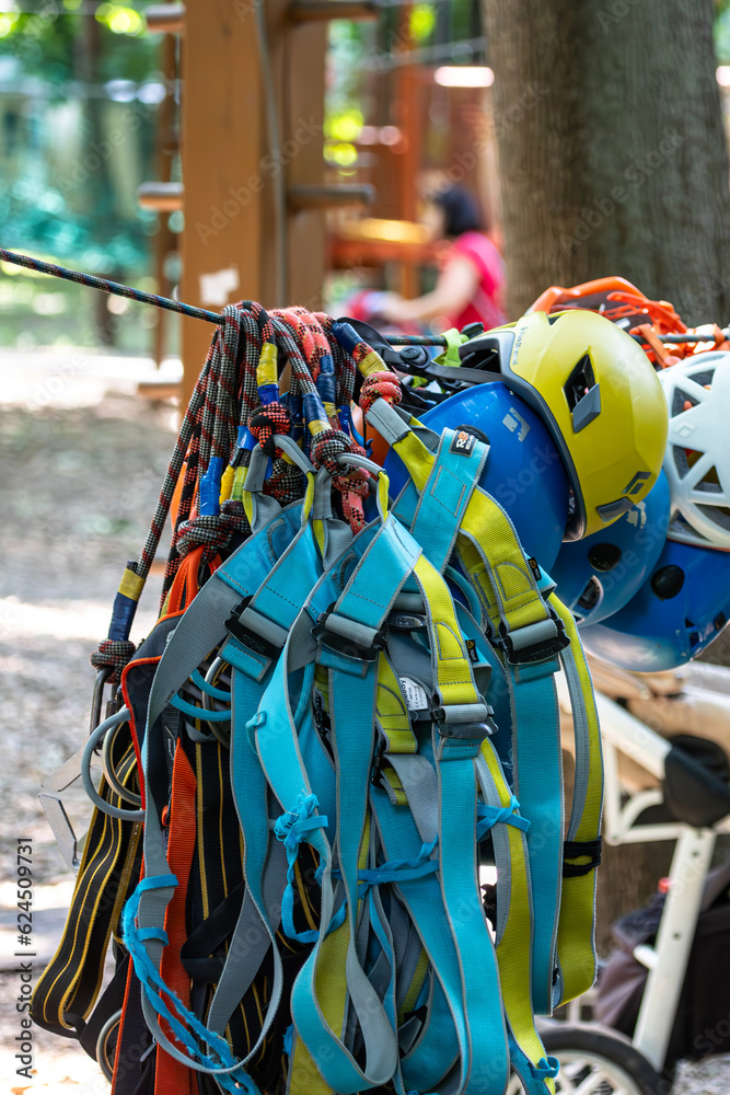Climbing equipment and helmets in the rope park. Sports activity. Rope ...