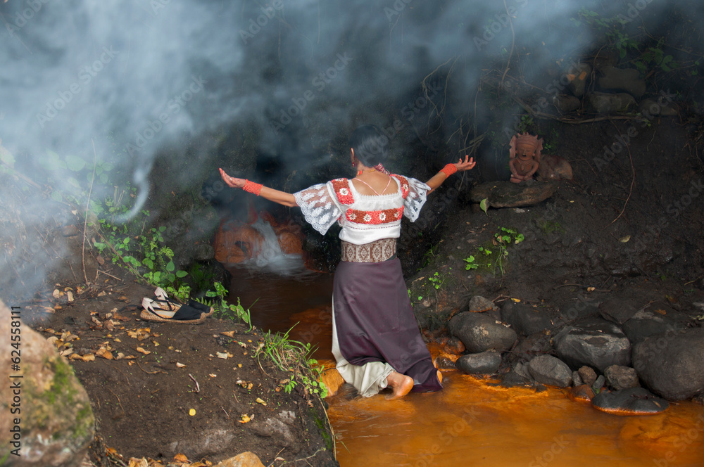 indigenous woman inside a sacred lagoon of volcanic water with smoke ...
