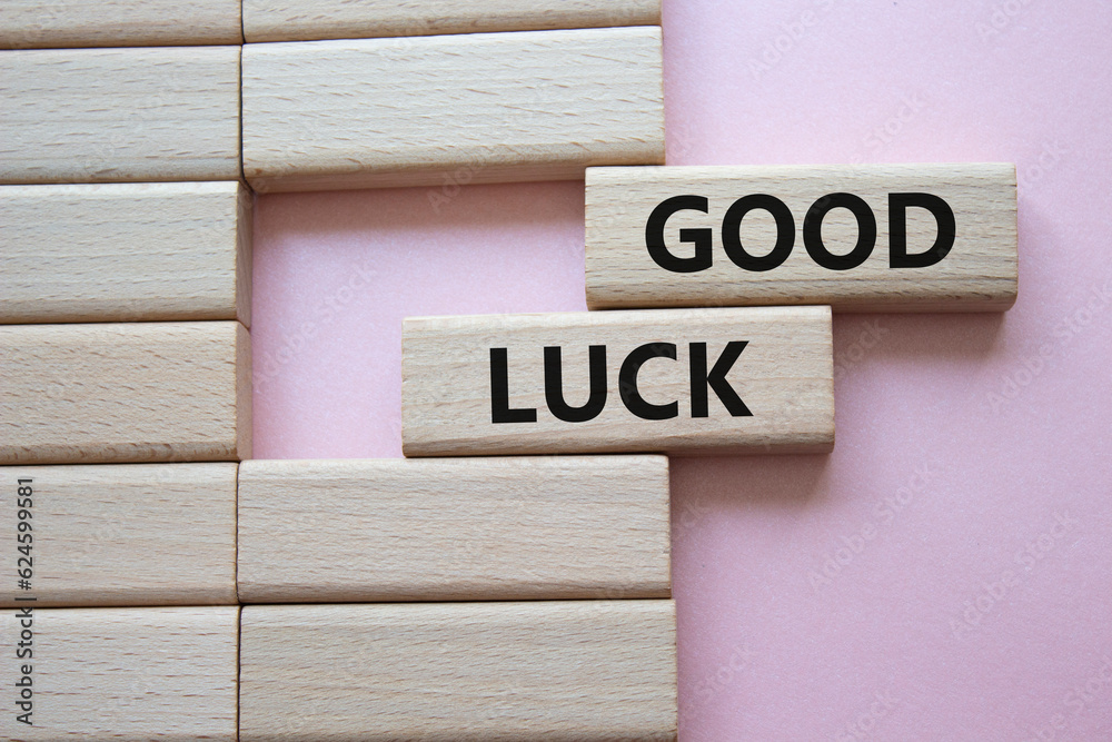 Good luck symbol. Wooden blocks with words Good luck. Beautiful pink ...