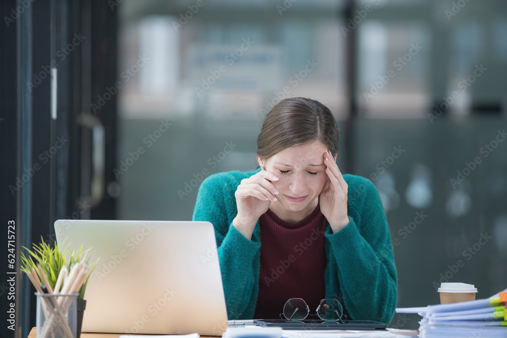 Depressed businesswoman crying in the office, suffering burnout at work ...