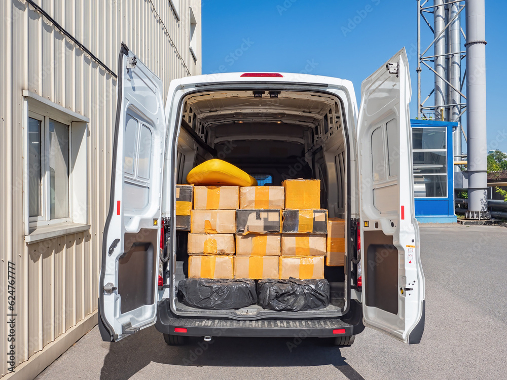 Boxes are loaded into minivan. Parcels are wrapped with yellow tape ...
