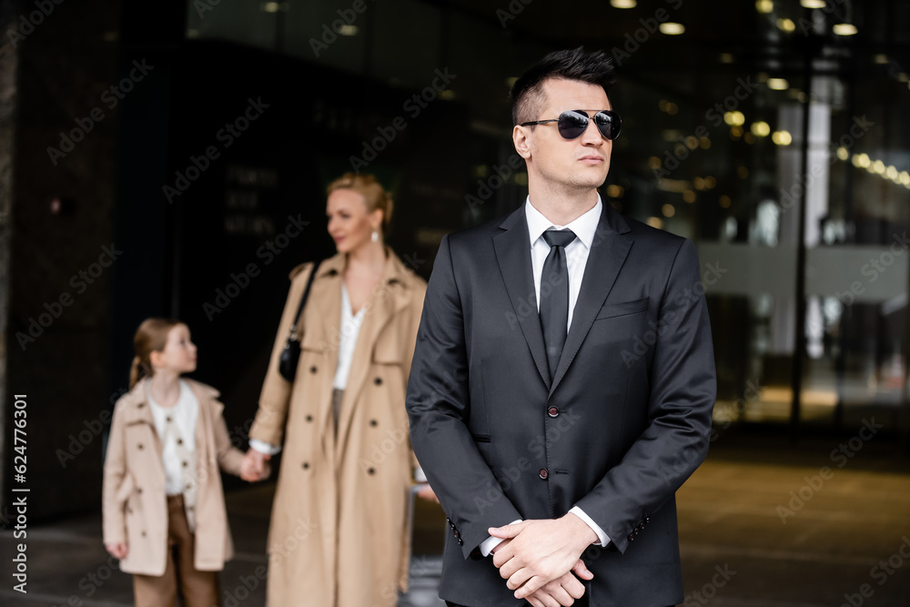 personal security, lifestyle, bodyguard in suit standing near ...