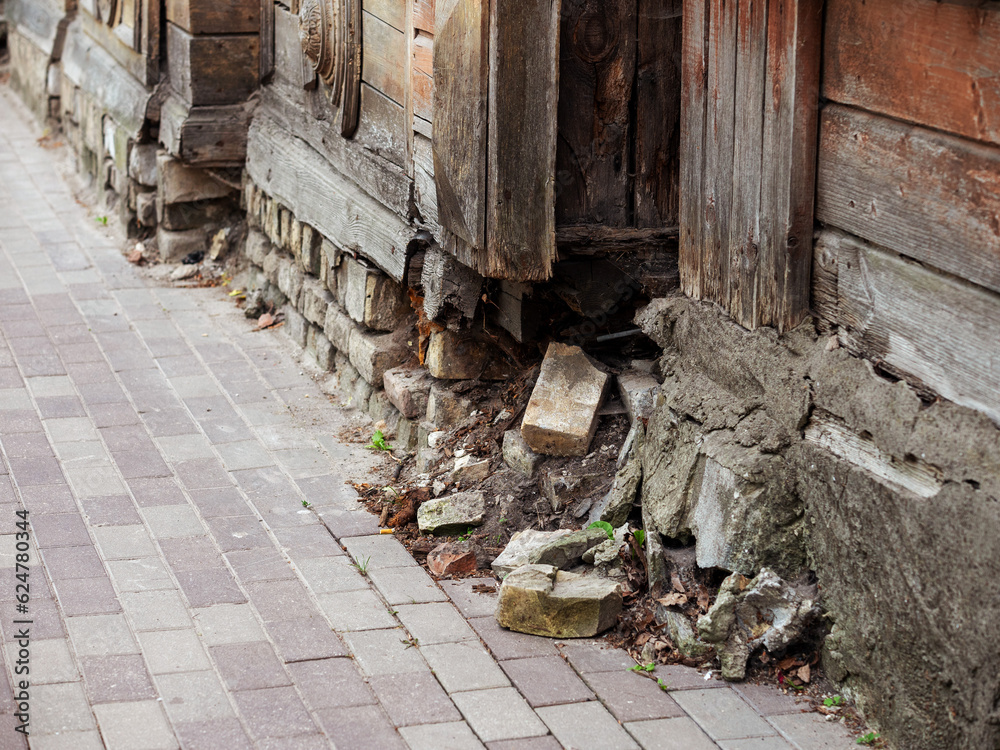 Old wooden building with falling apart brick and concrete basement ...