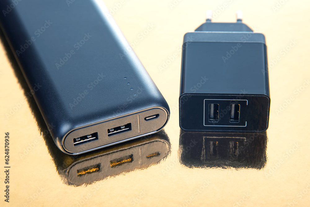 Power bank and charging plug on a golden background. Electronic devices ...