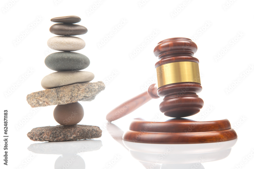 pyramid of stacked stones and a gavel of justice and law on a white ...