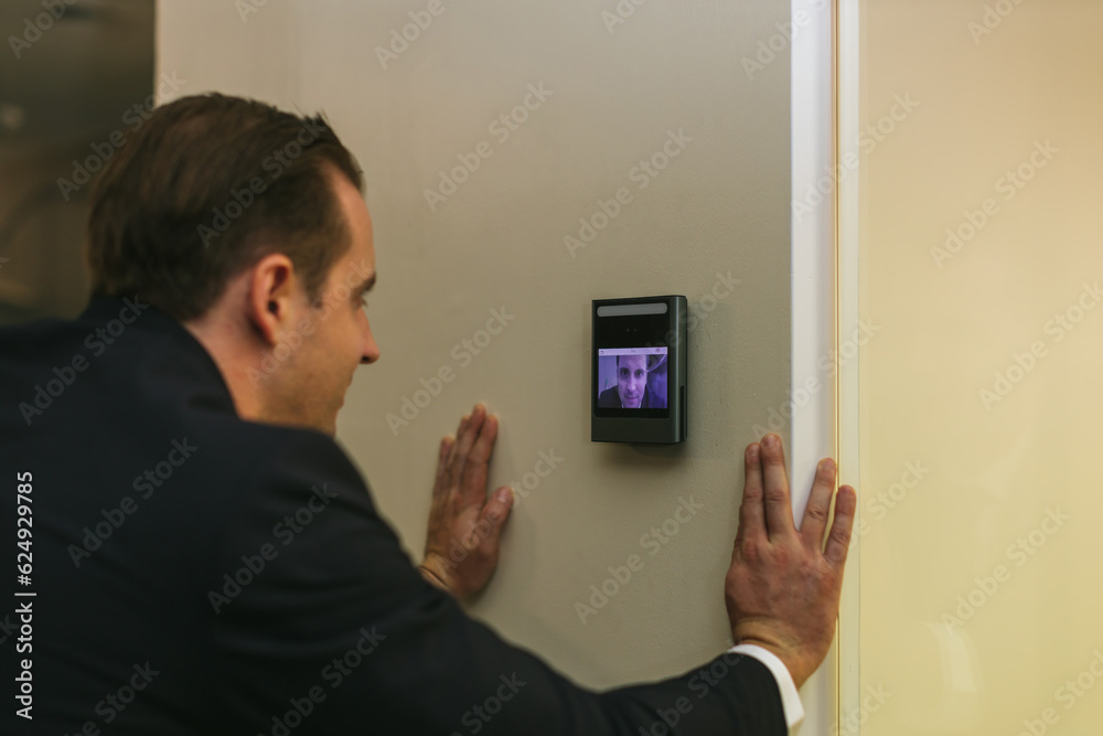 Man using face scanner to unlock door in office building. Access ...