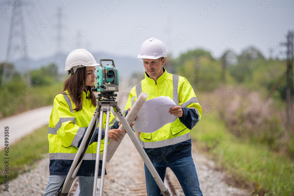 Surveyor engineers team wearing safety uniform,helmet and blueprint ...