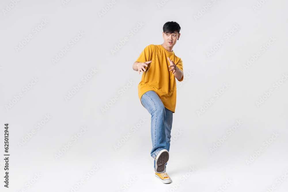 Full length of a handsome asian man pointing out to present something ...