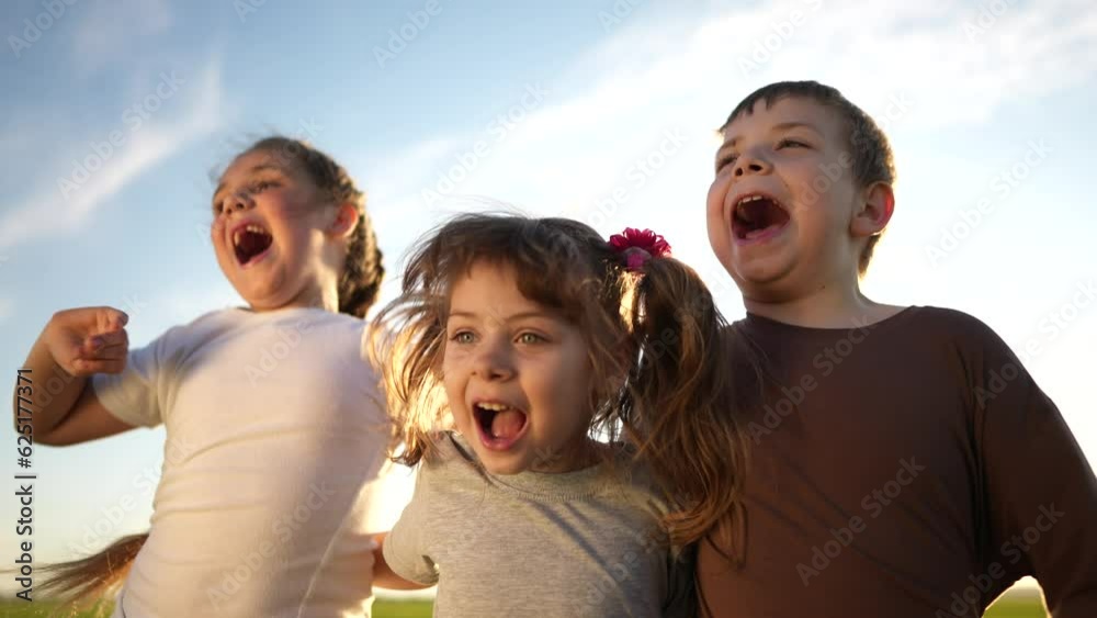 group of kids team hugging a jumping and rejoicing outdoors. happy ...
