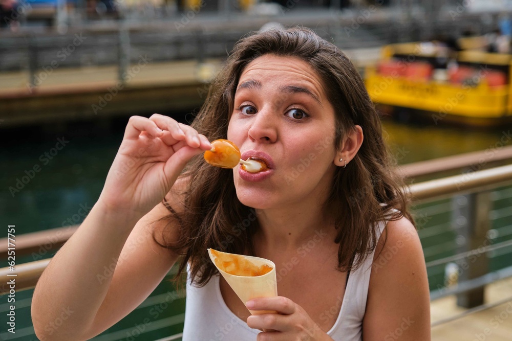 Tourist eating mitarashi dango, traditional Japanese rice dumplings ...