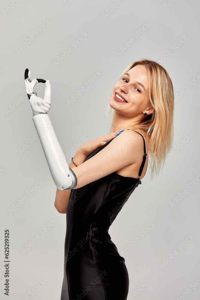 Studio portrait of beautiful young blonde girl with disability wearing ...