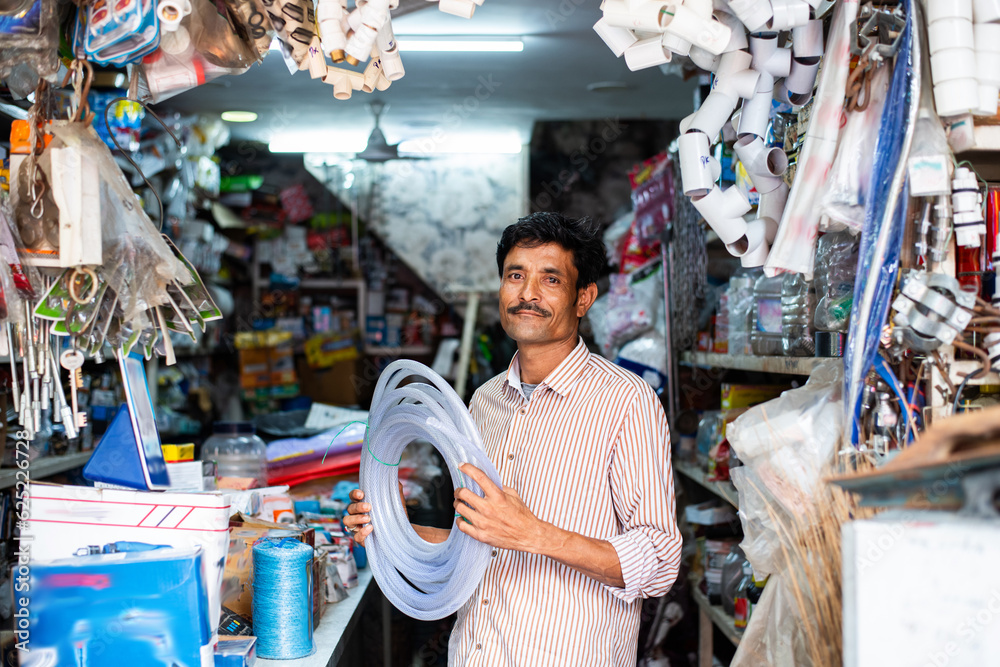 Indian hardware shop owner, salesman, vendor or seller showing products ...