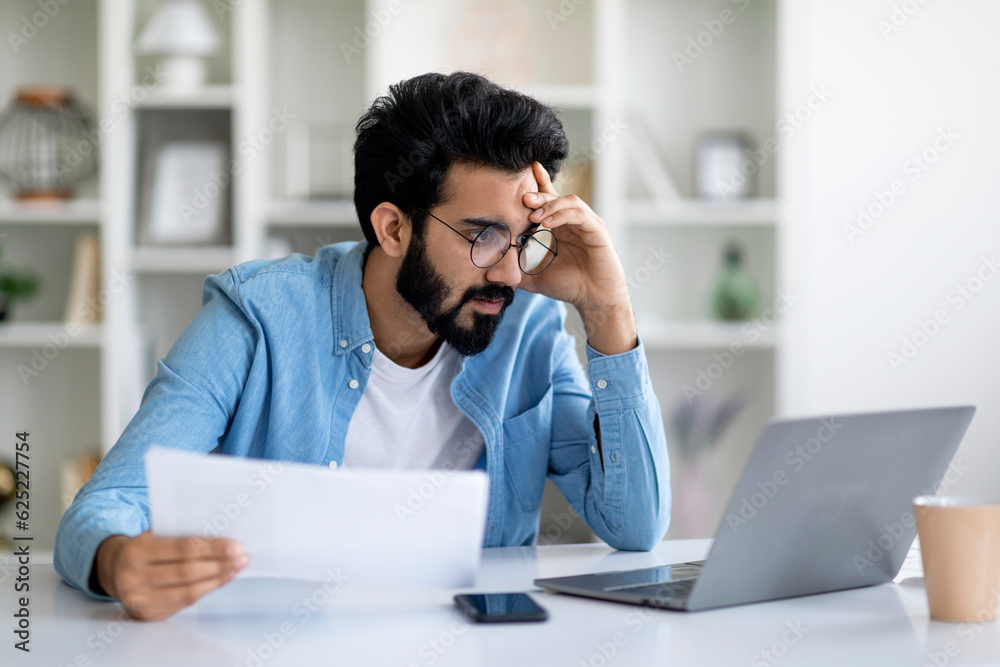Stressed Young Indian Man Looking At Laptop Screen And Holding ...