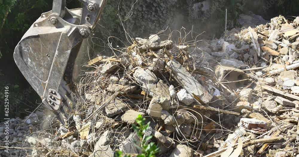 Backhoe excavator clearing up the area after the demolition. Bulldozer ...