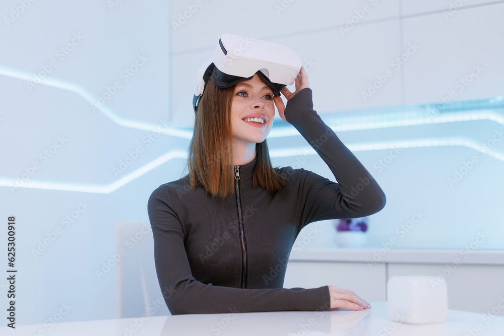 Woman in futuristic costume. Female in modern VR glasses interacting with network while having ...