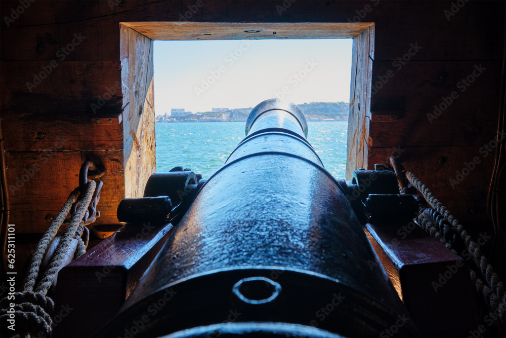 Sea view out of a gunport in hull of the ship over the gun cannon ...