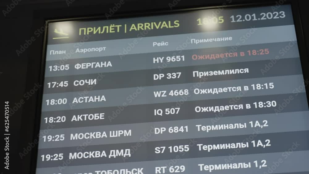 Monitor indicating arrivals of aircraft at busy airport terminal. Blue ...