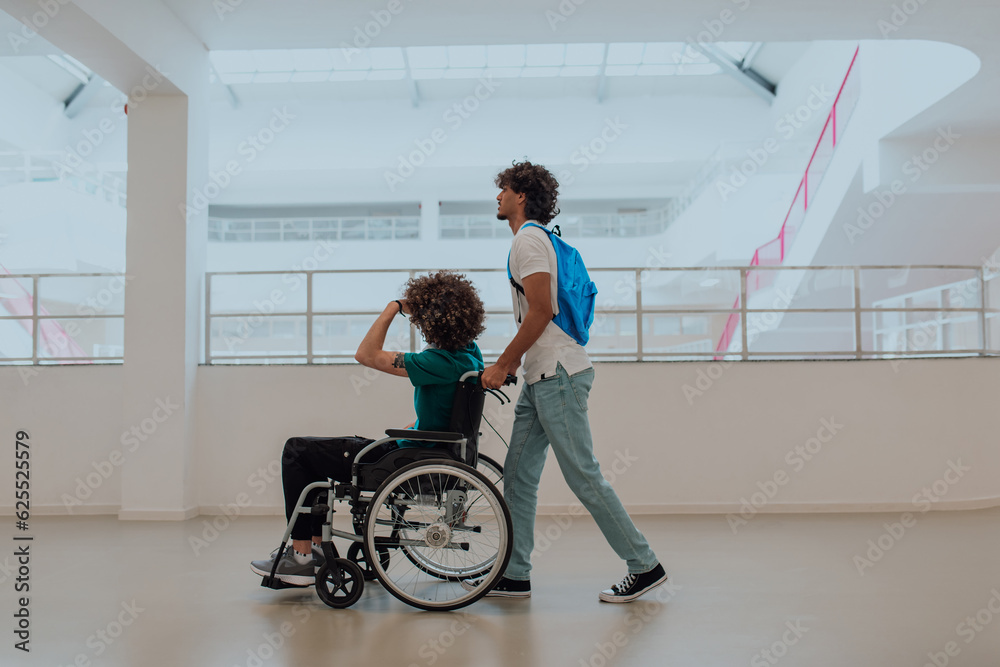African American student pushing his friend's wheelchair through a ...