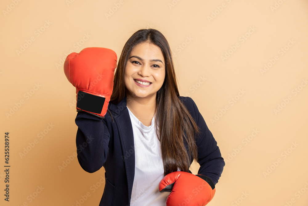Happy young indian woman employee wearing boxing gloves punching ...