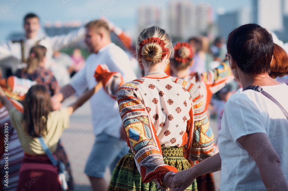 Folklore ensemble of a round dance on the embankment. Spectators dance ...