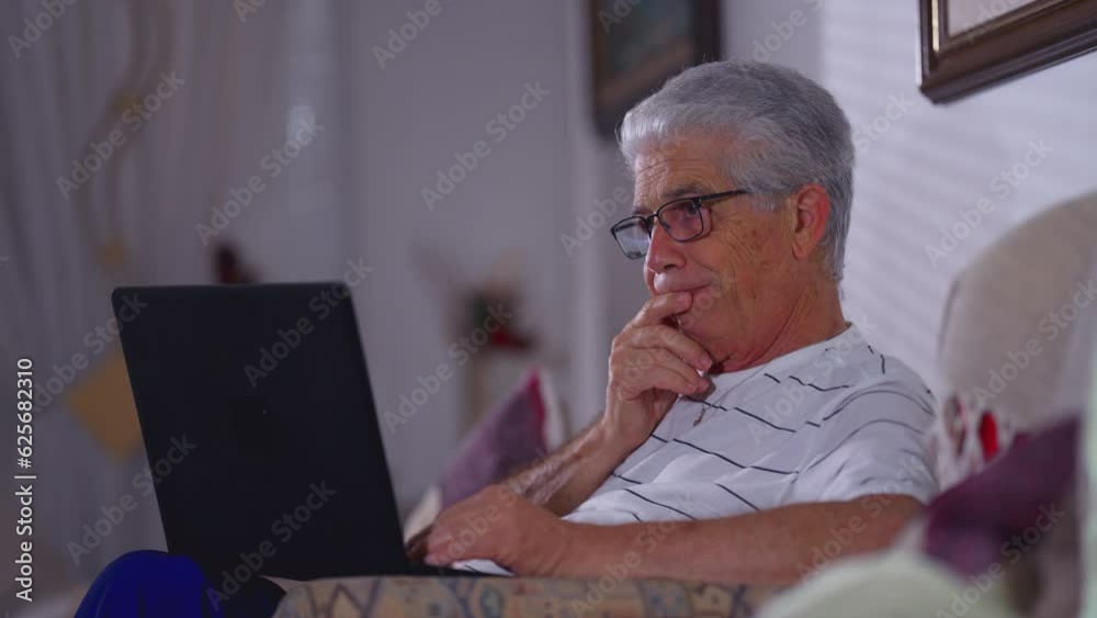 Concerned senior man in front of laptop computer with preoccupied ...