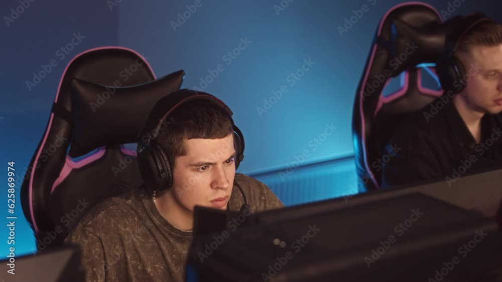 Slowmo of two young Caucasian male gamers playing in team in multiple ...