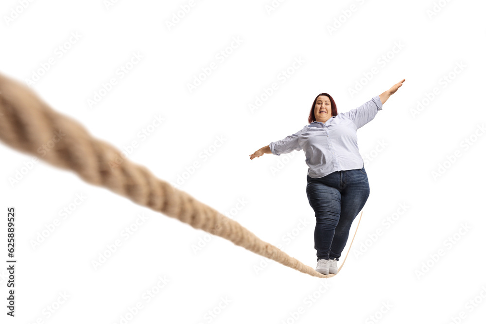 Full length portrait of a scared overweight woman walking on a rope ...