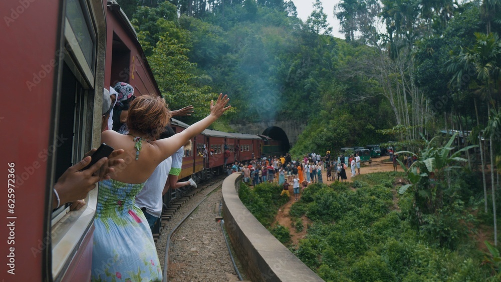 Nine Arches Bridge. Girl leans out of moving train waves to crowd on ...