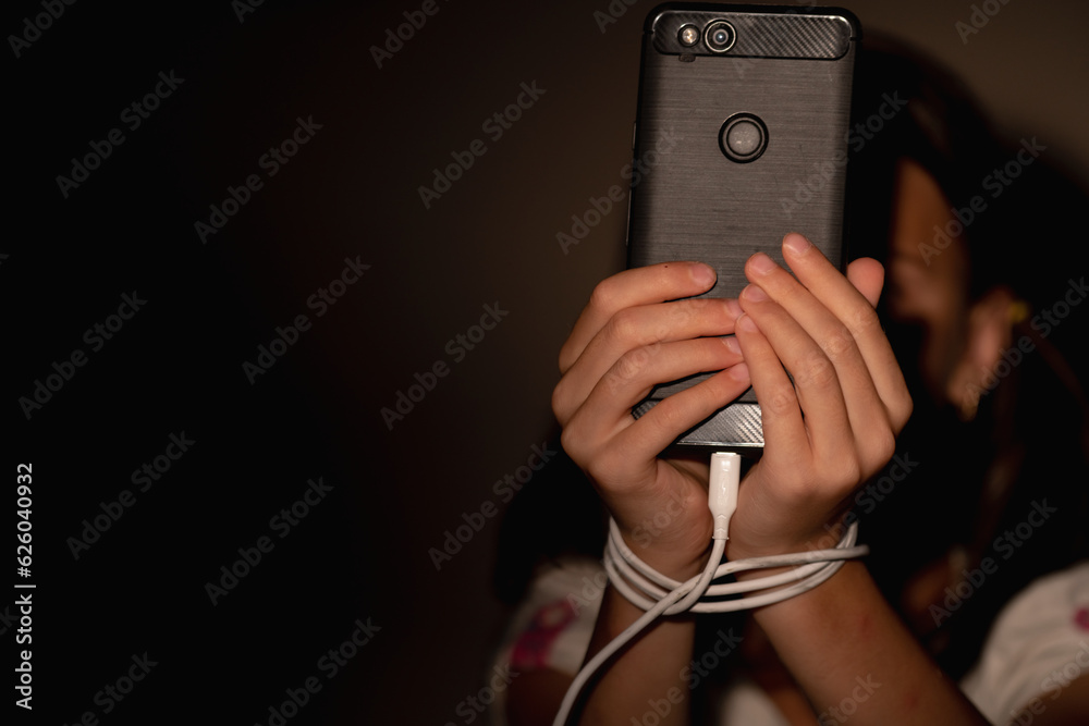 Young child girl playing smartphones during night time. She is chatting ...