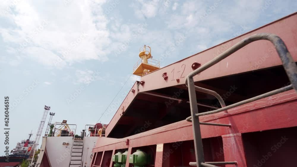 Seafarer opening cargo holds on bulker ship at grain terminal in sea ...