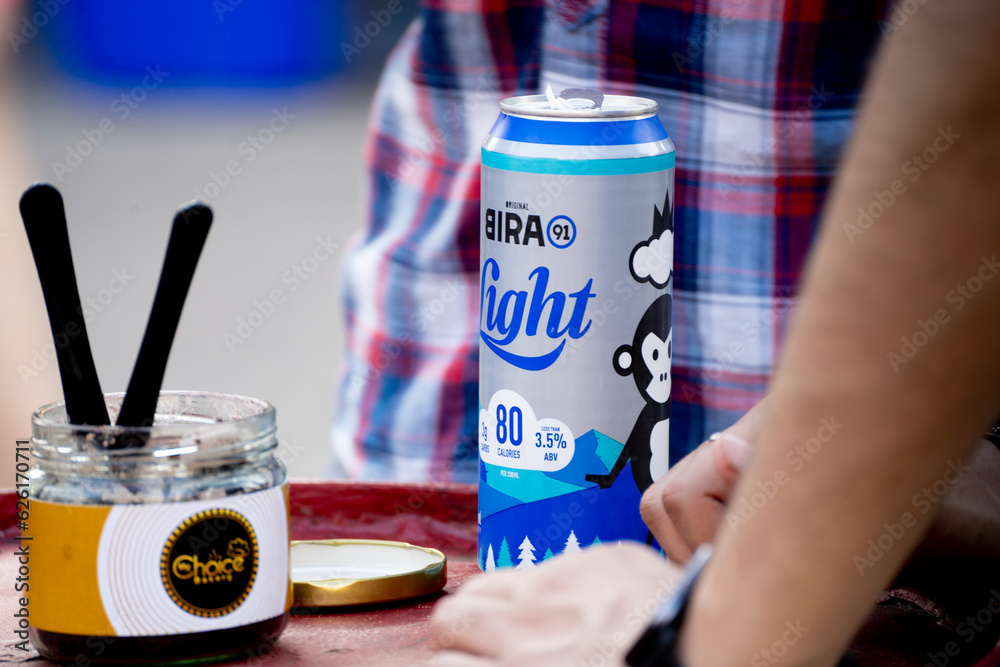 Can of Bira light beer placed on top of a table in an outdoor venue ...