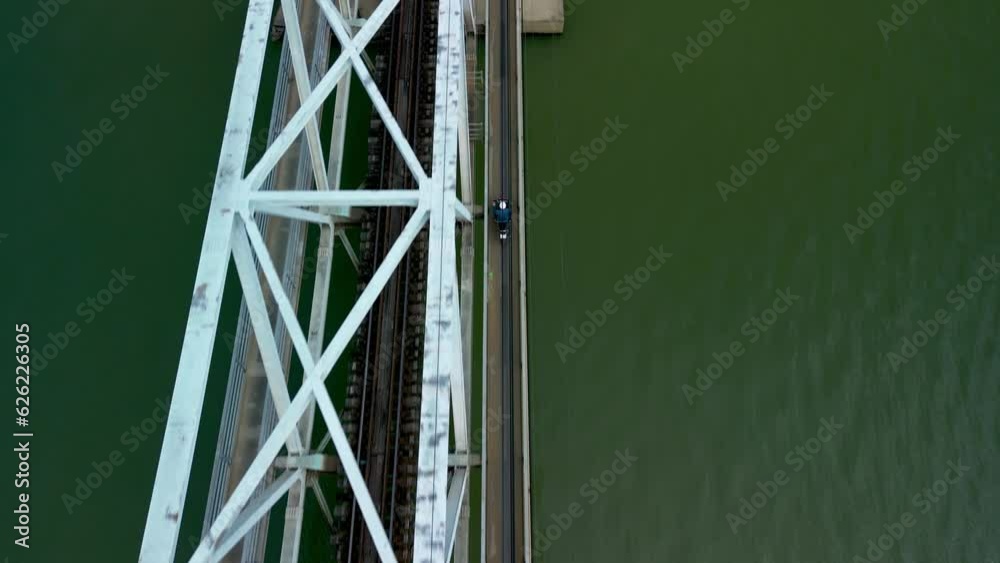 Aerial shot to biker riding on motorcycle on an iron bridge through ...