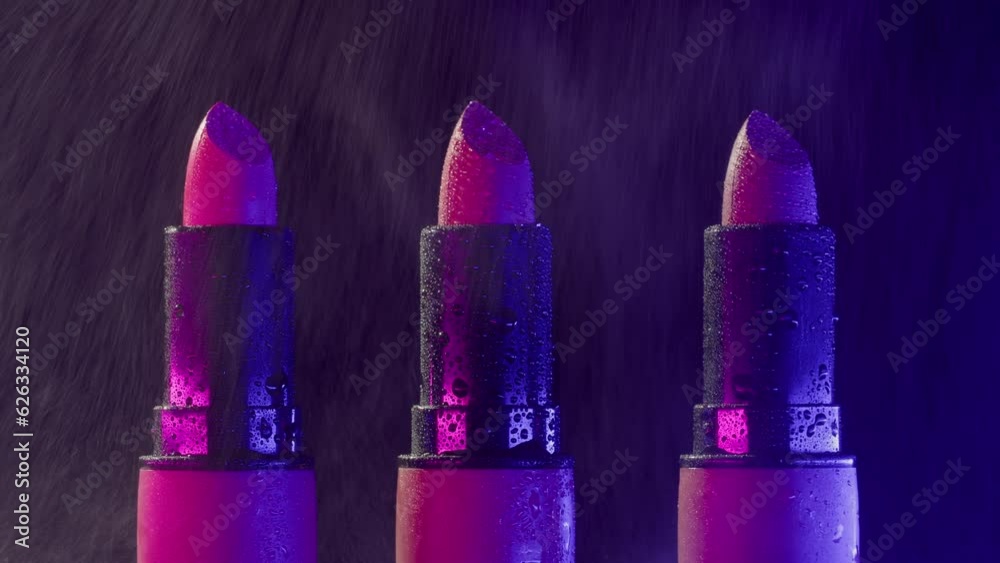 Red lipsticks make up close up background with smoke and water drops ...