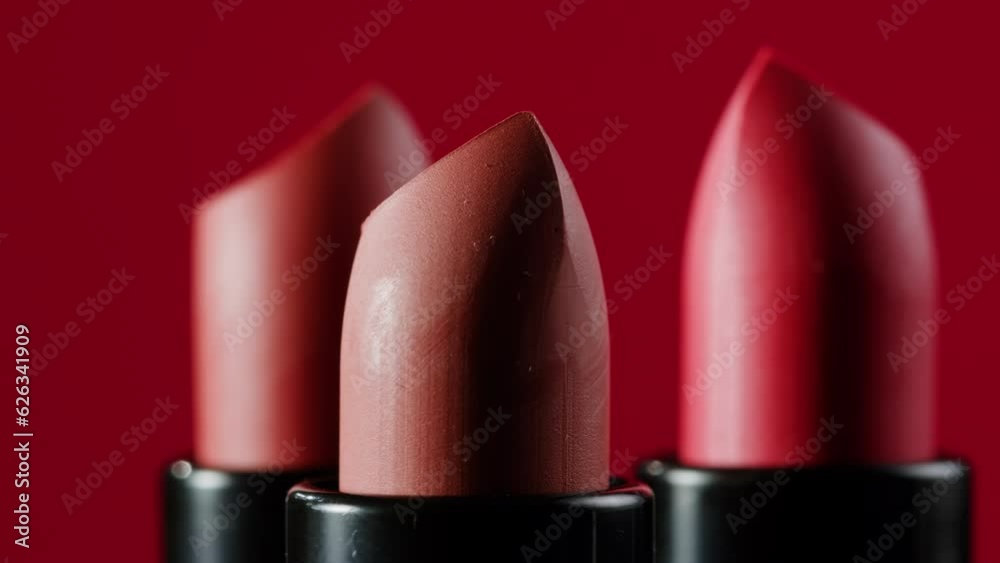 Red lipsticks make up close up background with smoke and water drops ...