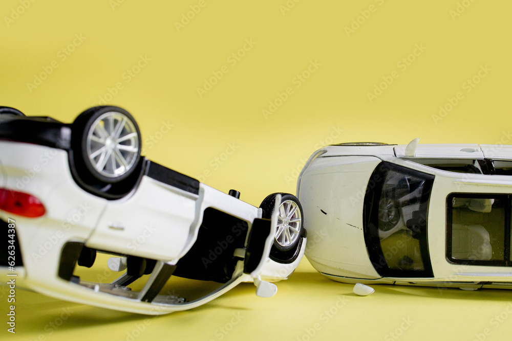 Two mini toy car crash on yellow background, incident, car traffic ...