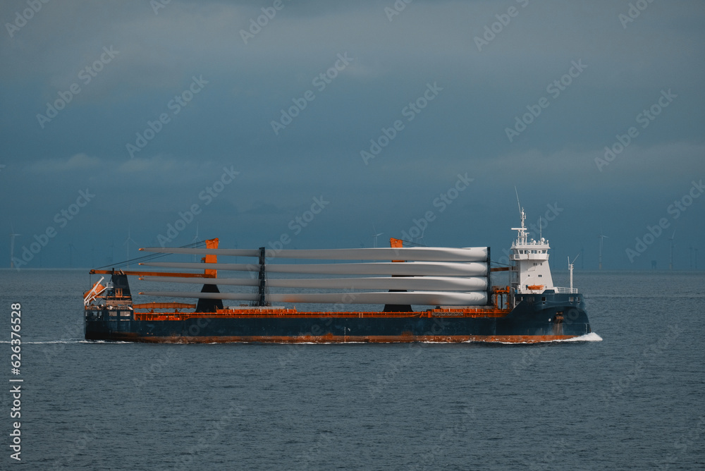 Heavy lift vessel with a cargo of wind blades underway during rainy ...